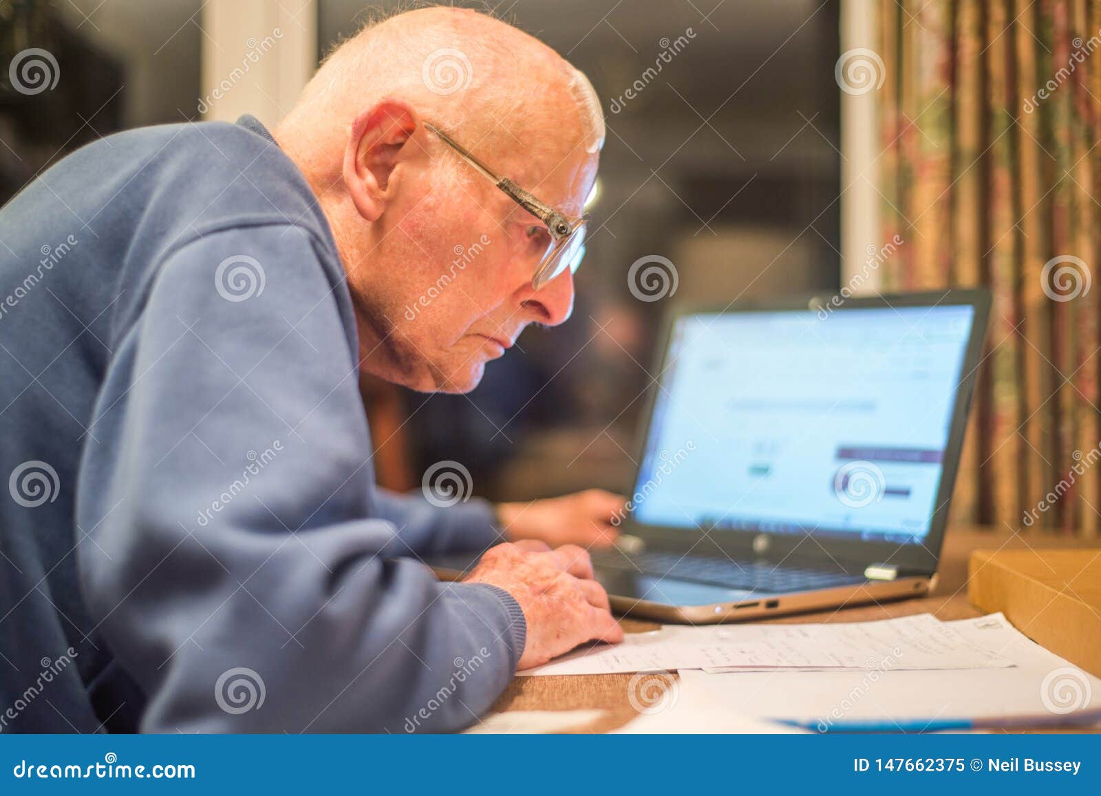 Elderly Man Using a Laptop Computer To Check Share Portfolios ... Elderly Man Using a Laptop Computer To Check Share Portfolios ...