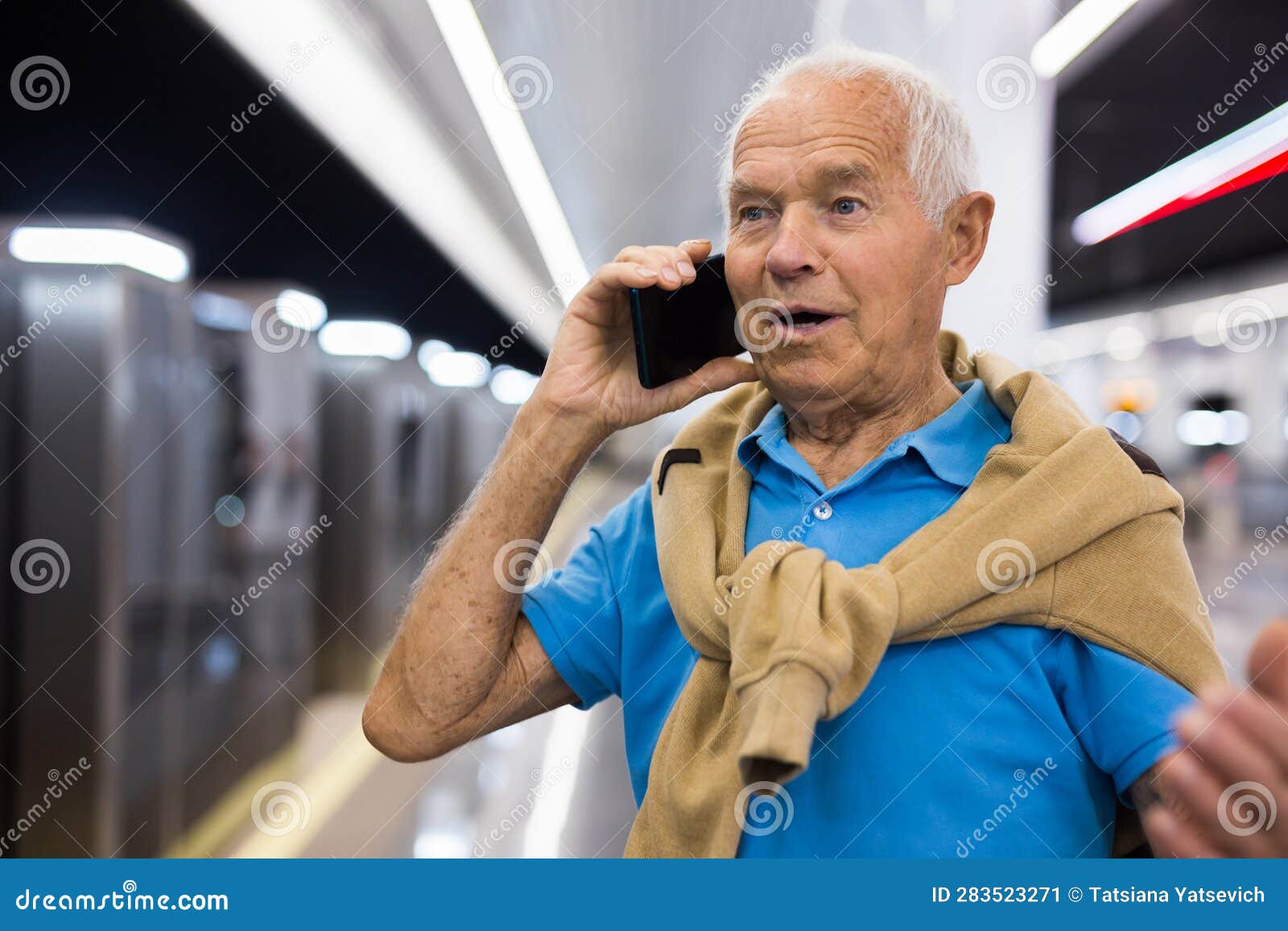 Elderly Man Using Mobile Phone while Waiting for Train in Platform of ...