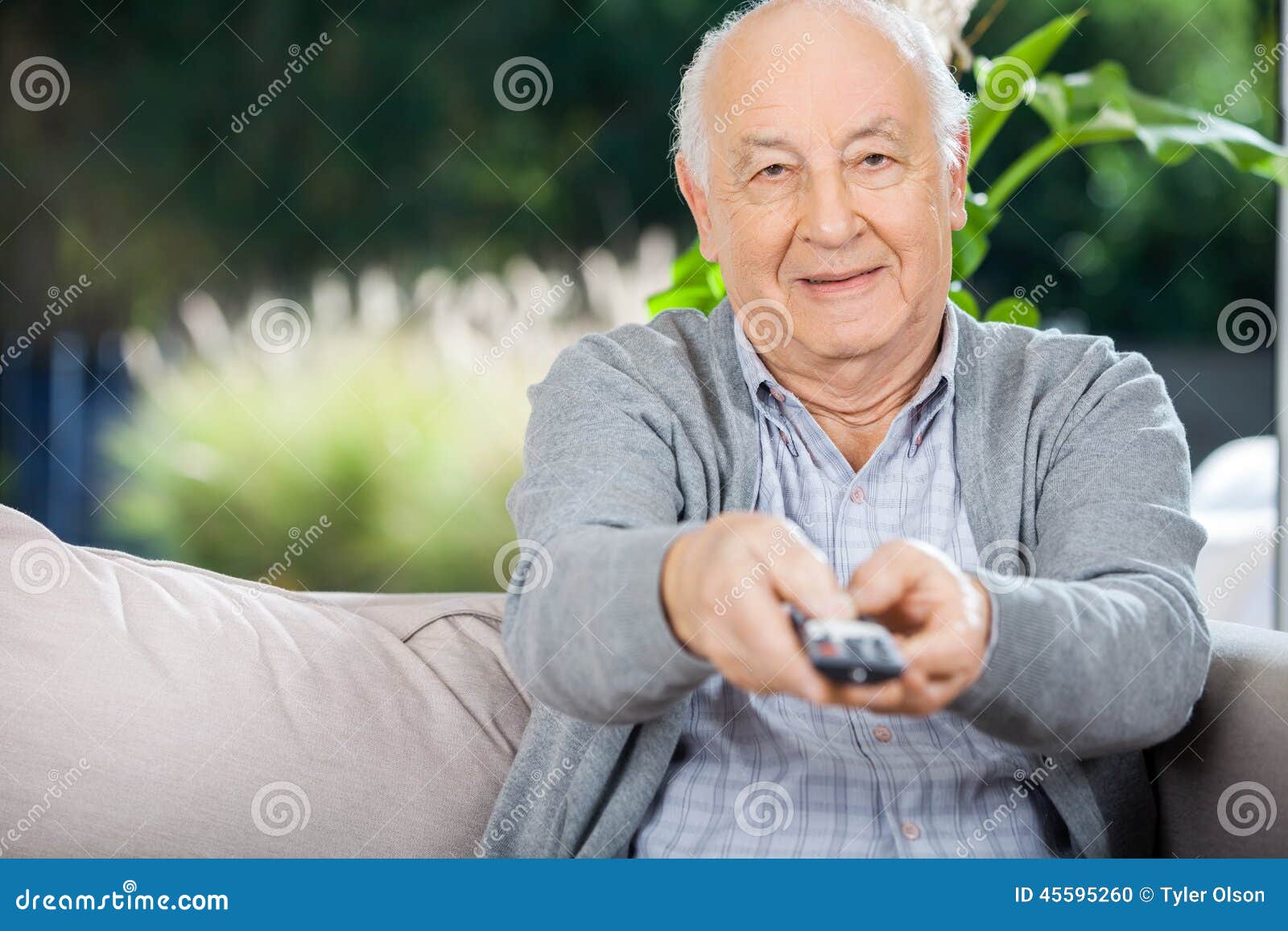 Elderly Man Using Remote Control while Sitting on Stock Photo - Image ...