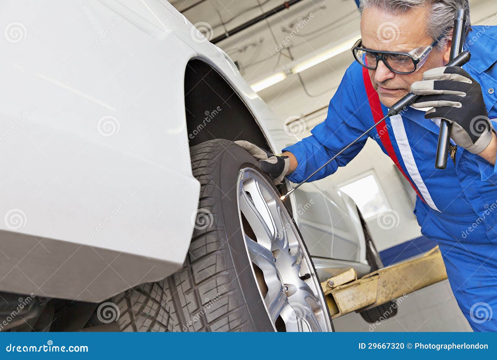 Elderly Man Working on Car Tire Stock Photo - Image of eyewear, vehicle ...