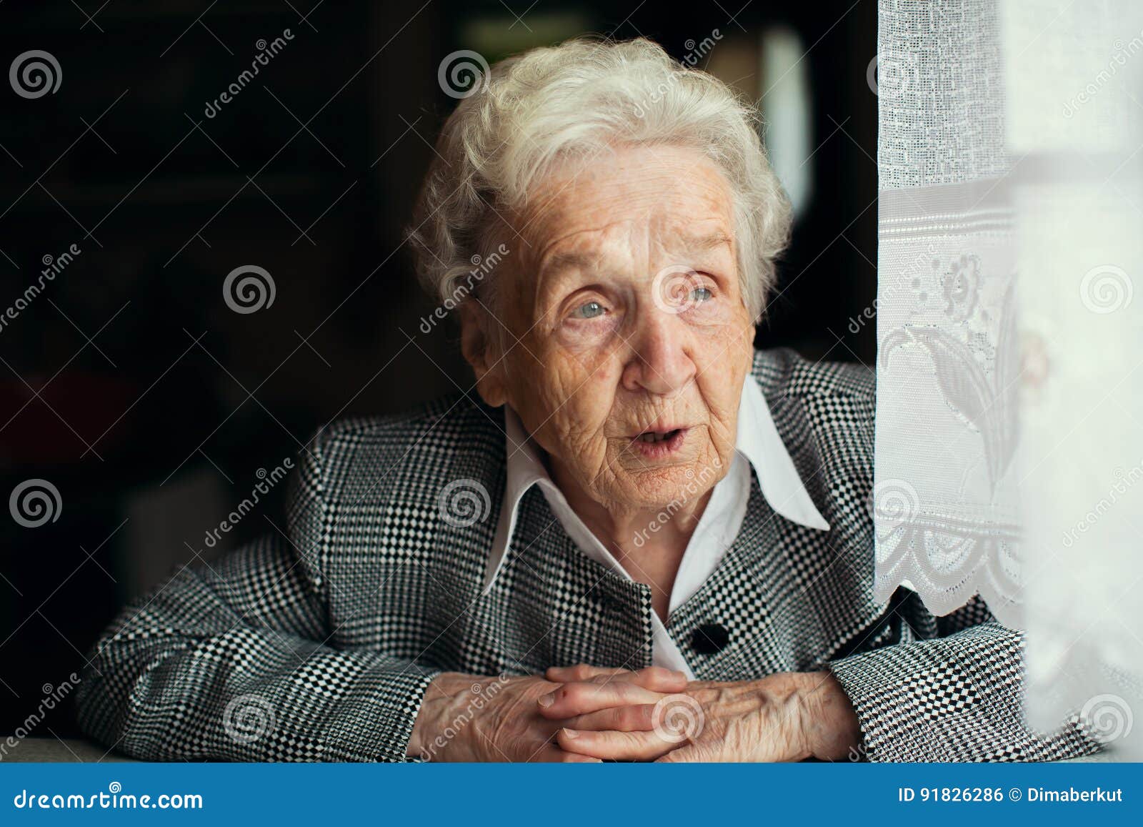 An Elderly Woman Thinking Sitting by the Window. Pensioner. Stock Photo ...