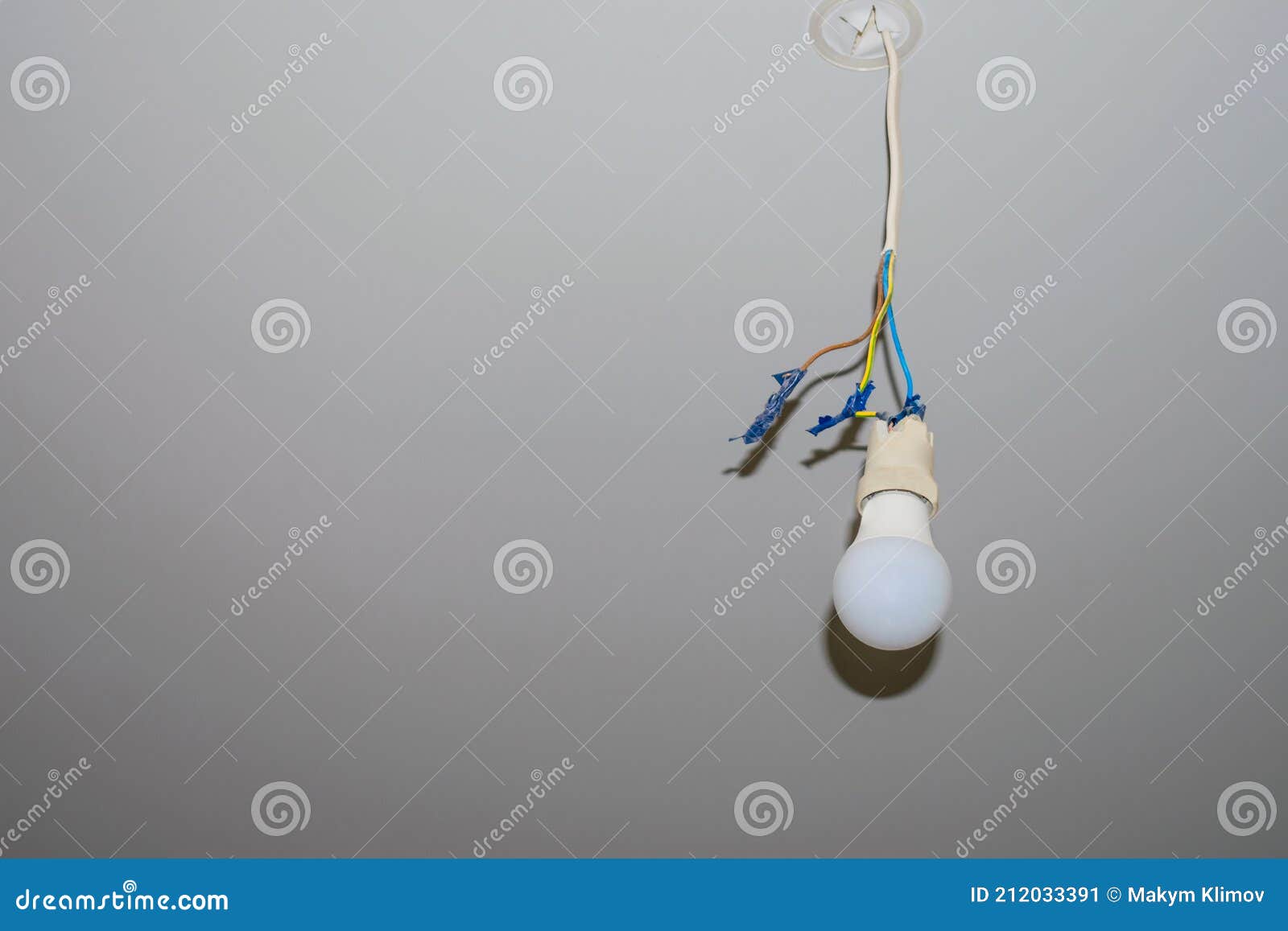 An Electric Bulb Hanging on a Wire Against a White Stretch Ceiling ...
