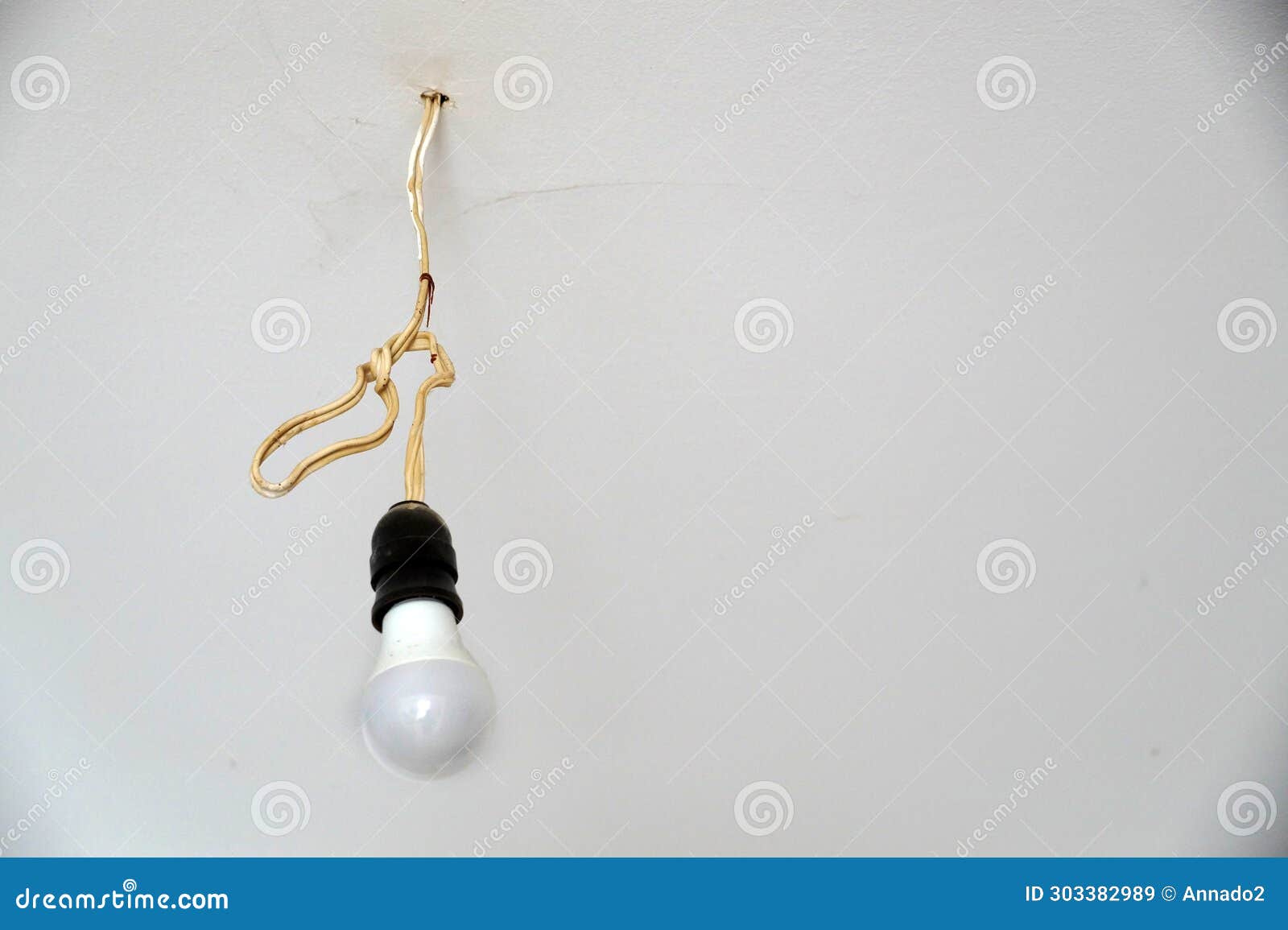Electric Energy Saving Light Bulb Hanging on a Wire on the Ceiling ...