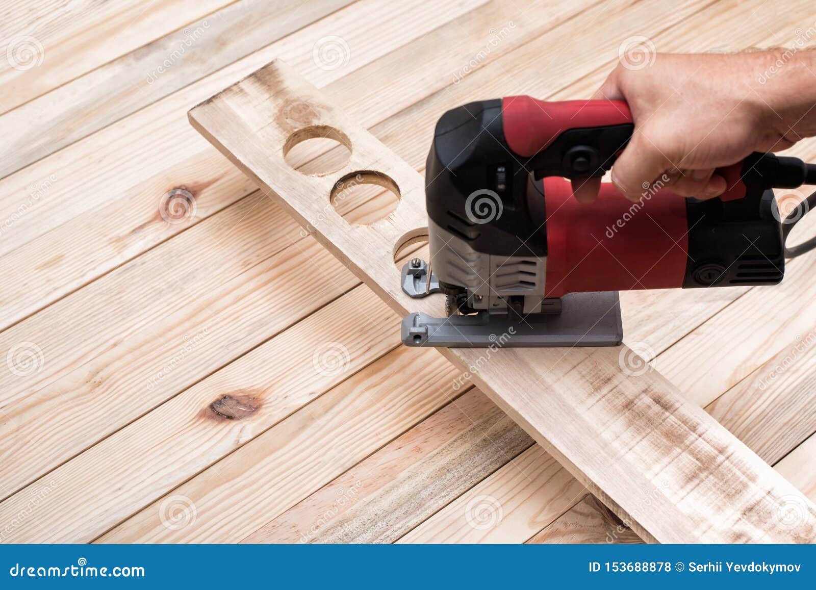 Electric Jigsaw in Male Hand. Processing of Workpiece on Light Brown ...
