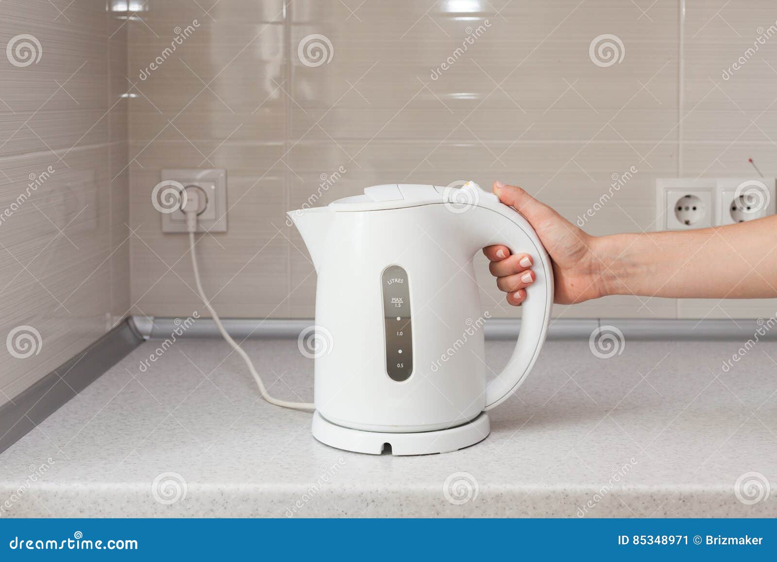 Electric Kettle in Hand on the Background of the Kitchen Stock Image ...