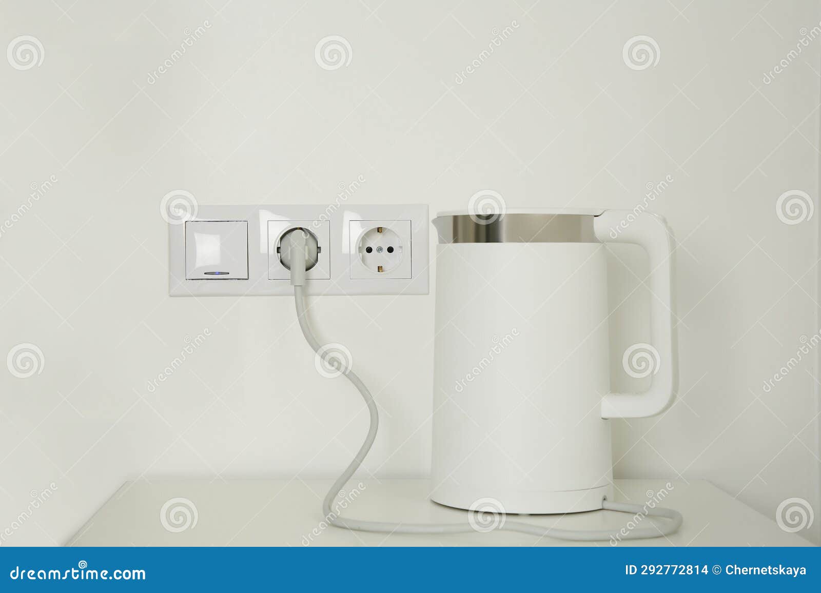 Electric Kettle Plugged into Power Socket on White Wall Stock Photo ...