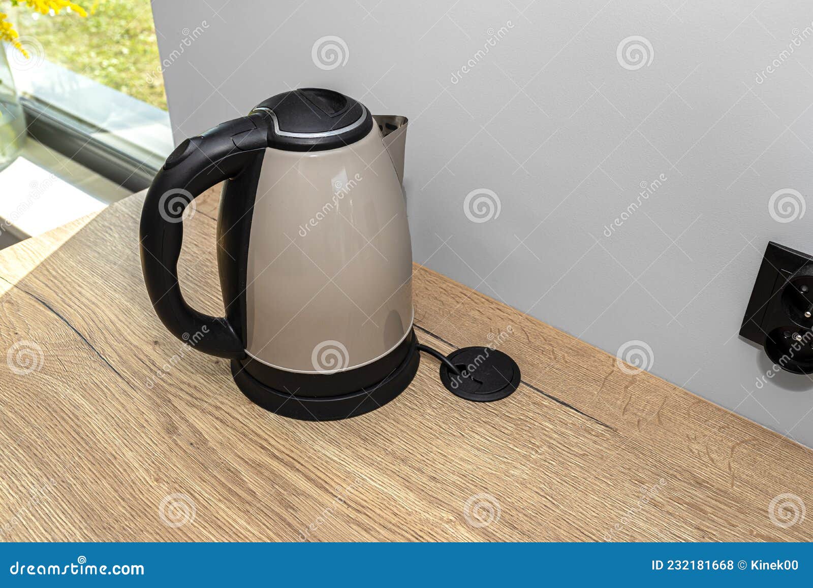 An Electric Kettle Standing on the Countertop on the Kitchen Cabinets ...