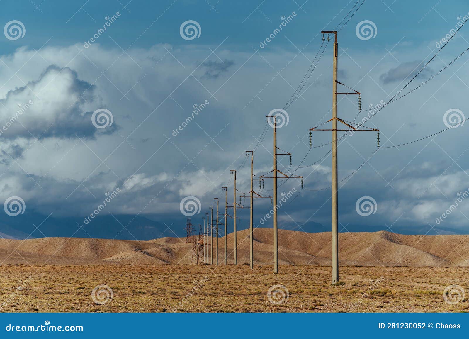 Electric Power Lines in Field on Mountains Background Stock Photo ...