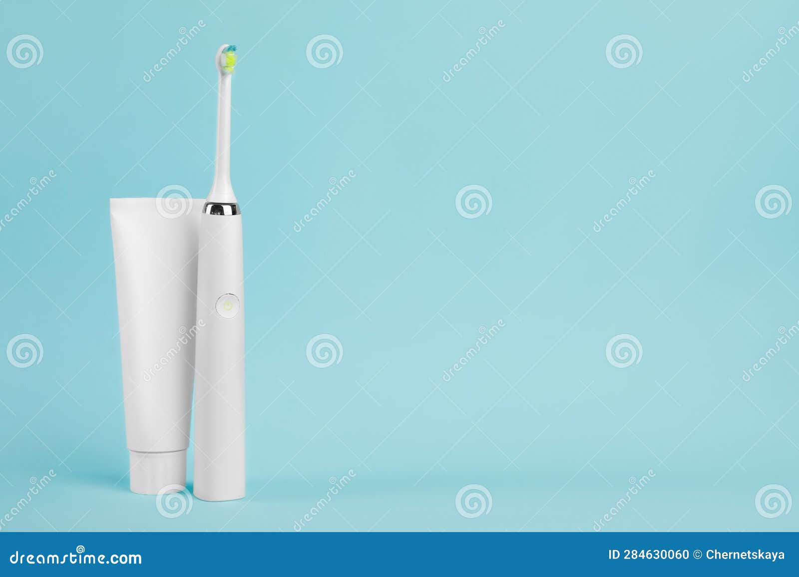 Electric Toothbrush and Toothpaste on Light Blue Background, Space for ...