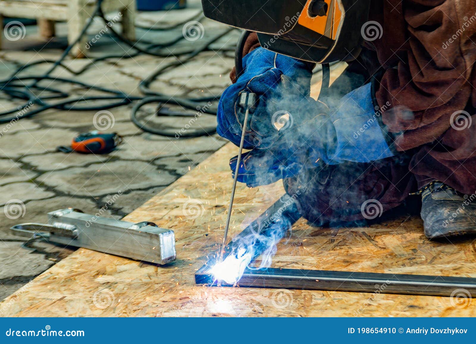 An Electric Welder Assembles a Metal Structure from a Shaped Pipe by ...