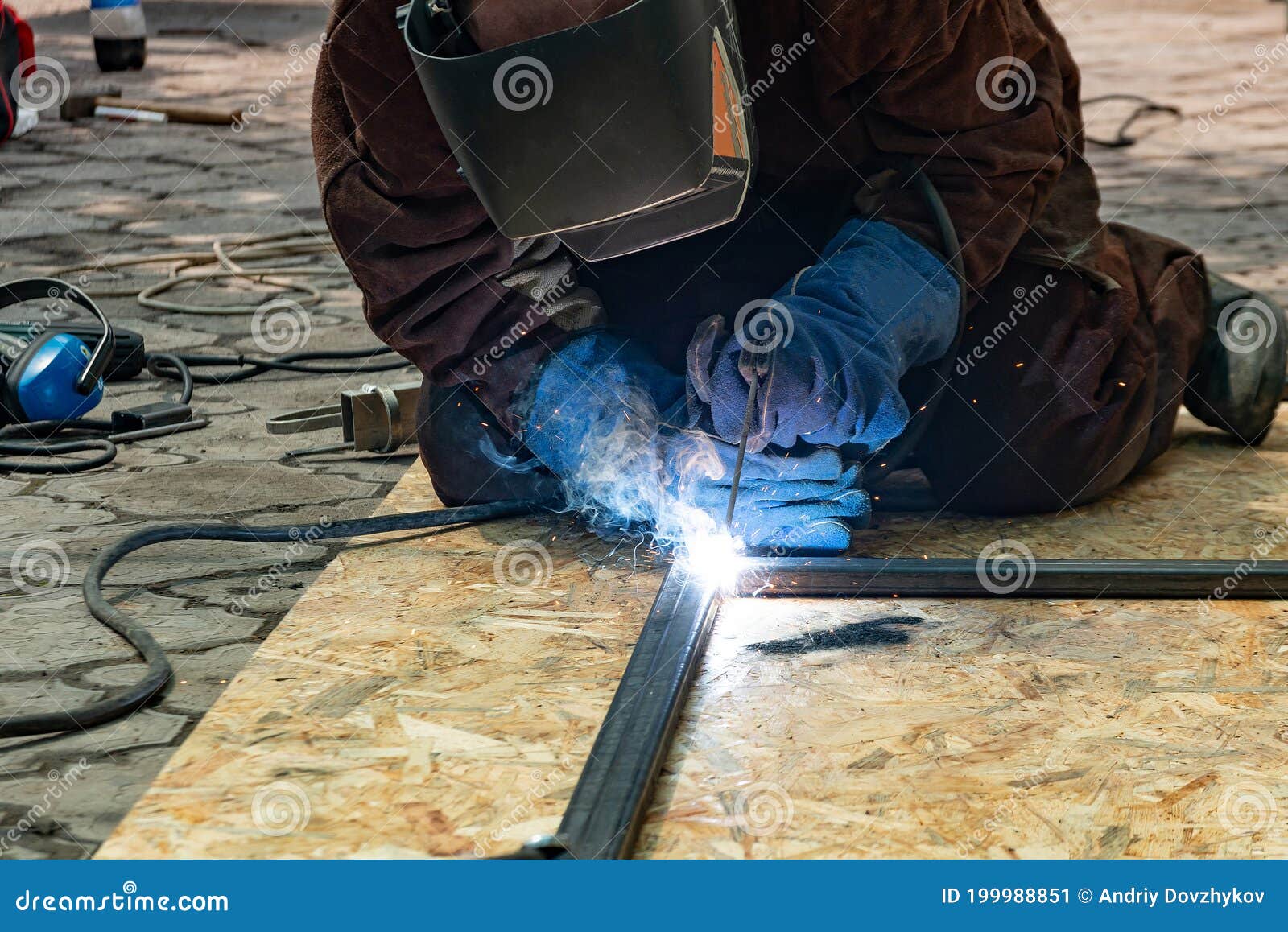 An Electric Welder Makes a Metal Structure by Connecting a Pipe with ...