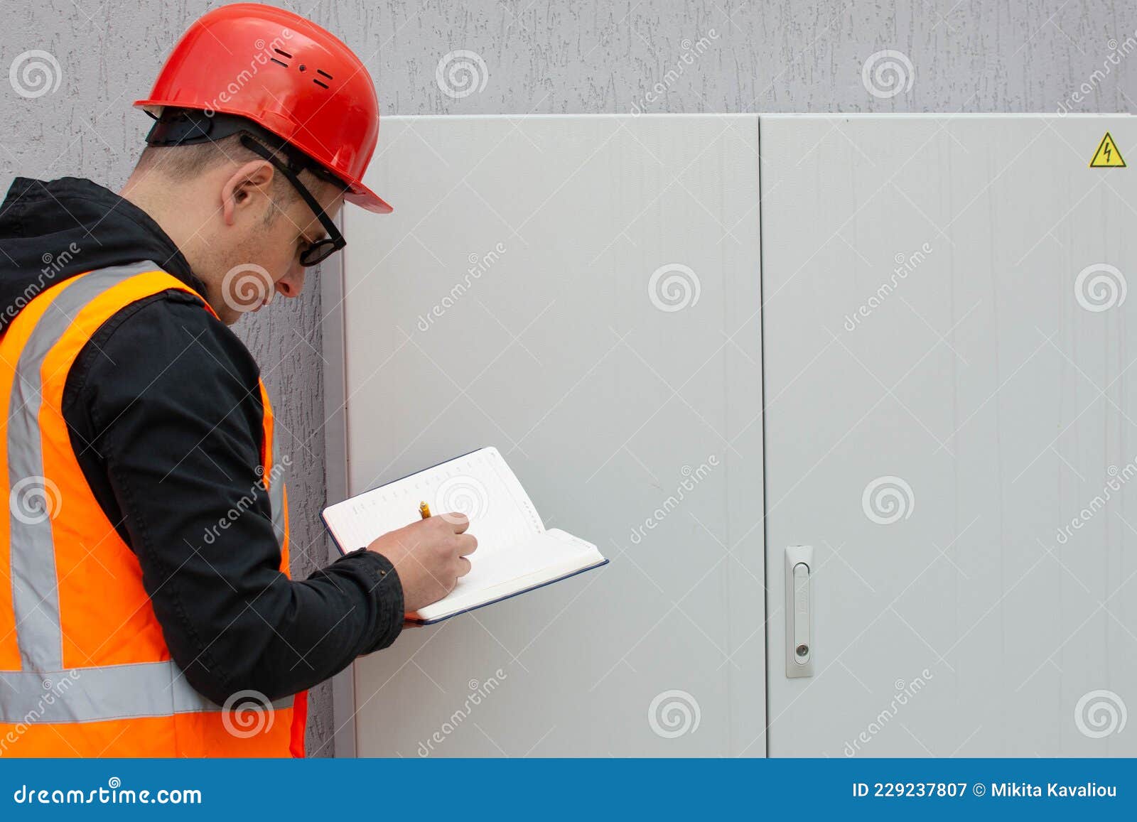 Electrical Engineer Inspects the Switchboard, Writing Down the Faults ...