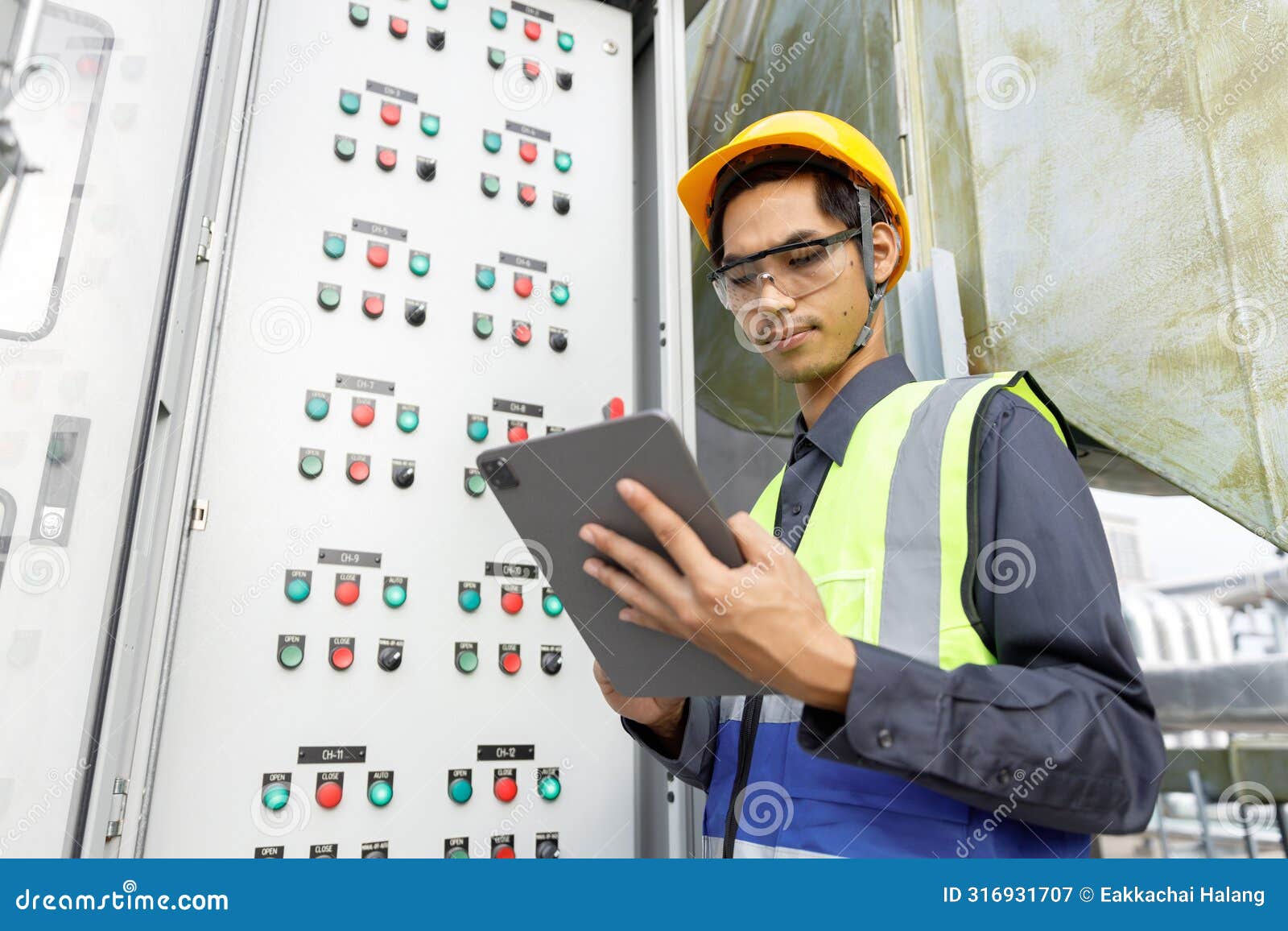 Electrical Engineer Man Using Tablet Checks Switchboard Main ...