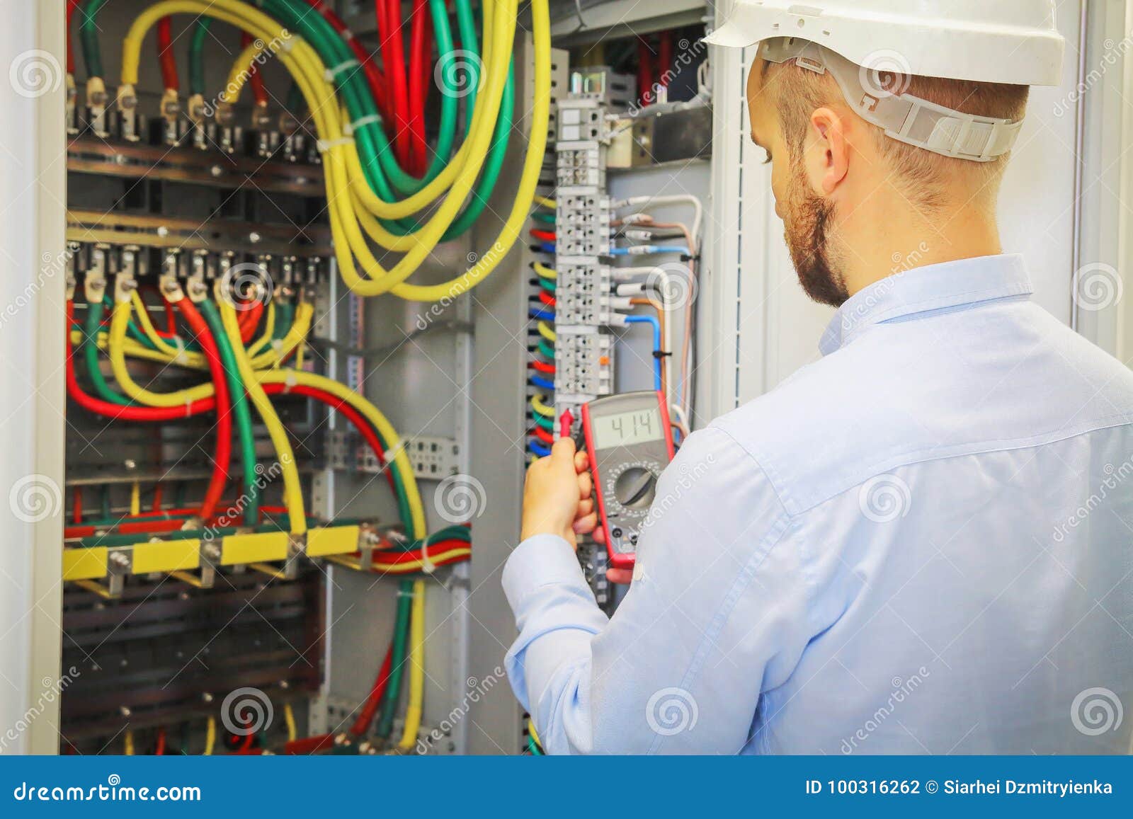 Electrical Engineer With Multimeter On Background Of Distribution ...