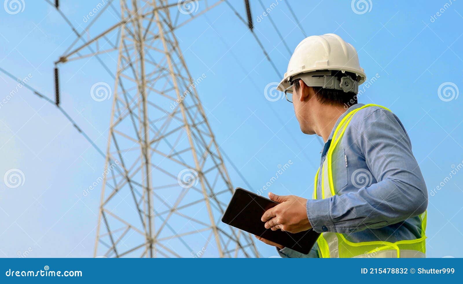 Electrical Engineer Working on Digital Tablet with Electric Power Pole ...