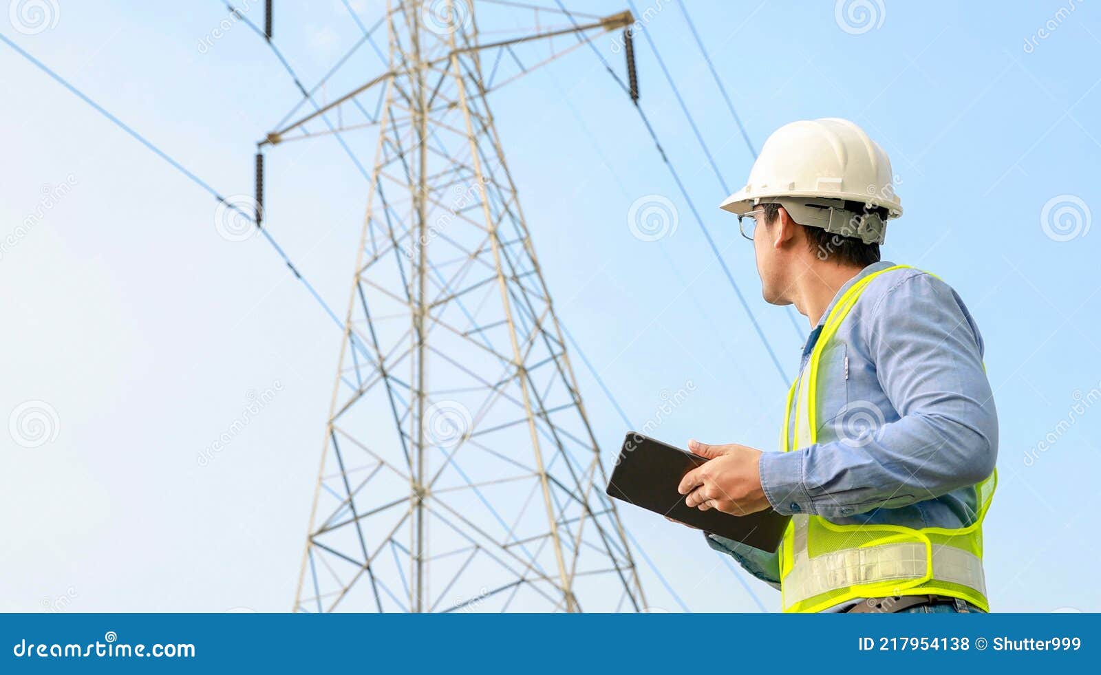 Electrical Engineer Working on Digital Tablet with Electric Power Pole ...