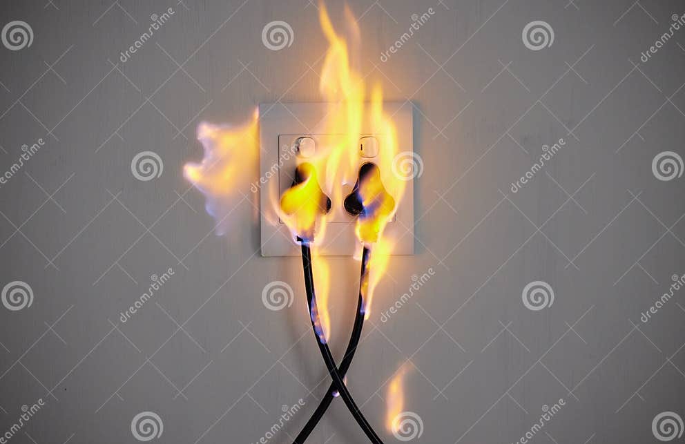 Electrical Fire. Two Plugs in a Wall Socket Catching Fire. Stock Image ...