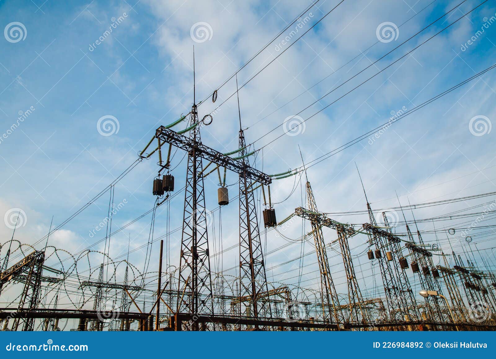 Electrical Pylons and High Voltage Power Lines are Behind a Barbed Wire ...