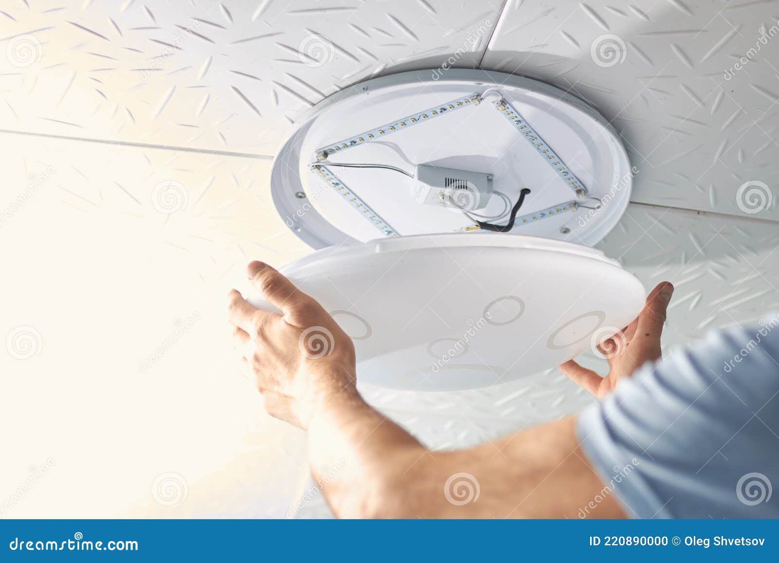 An Electrical Technician Changes a Low-consumption LED Lamp into a ...