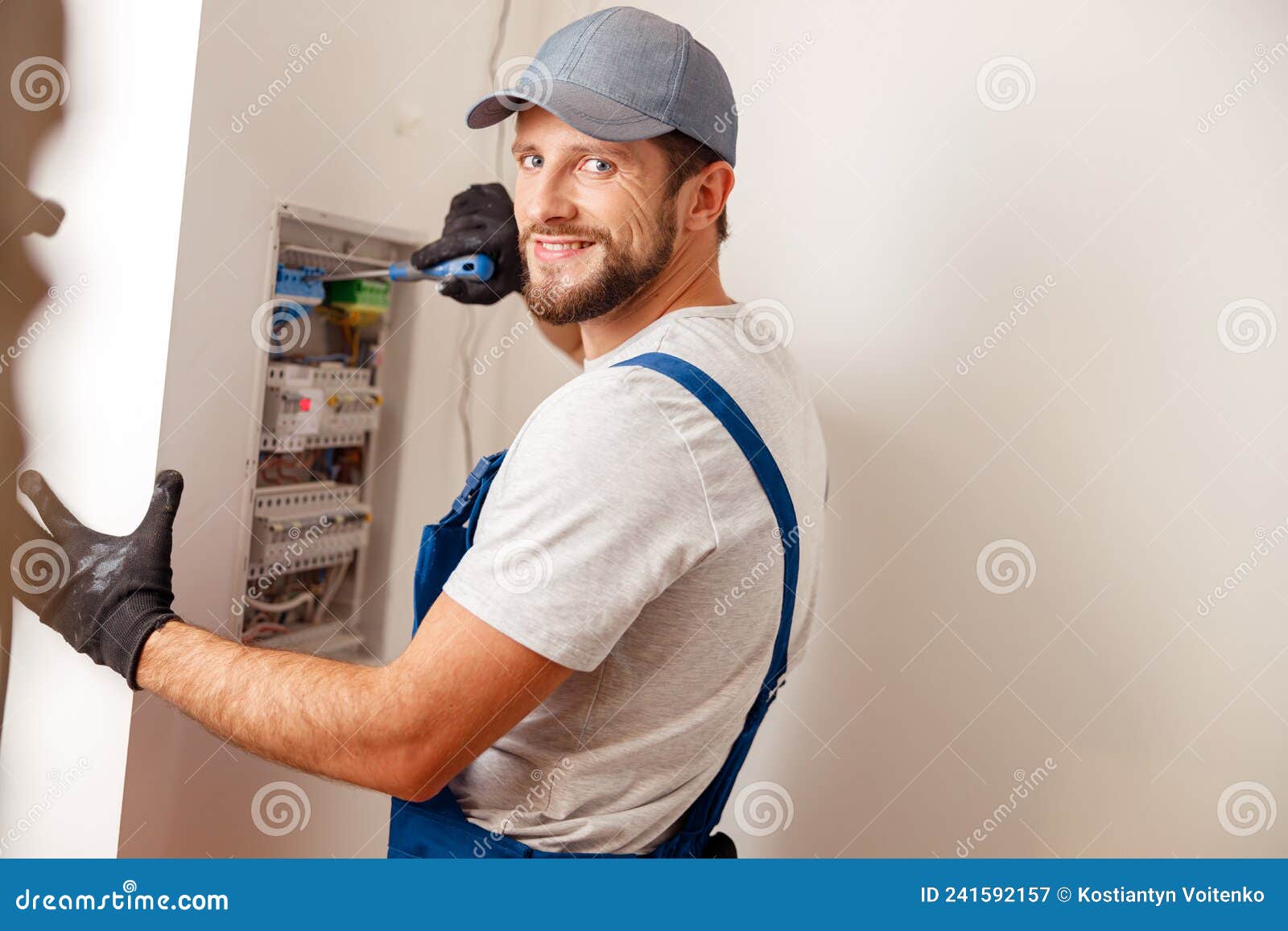 Electrical Technician in Uniform Smiling at Camera, Using Screwdriver ...