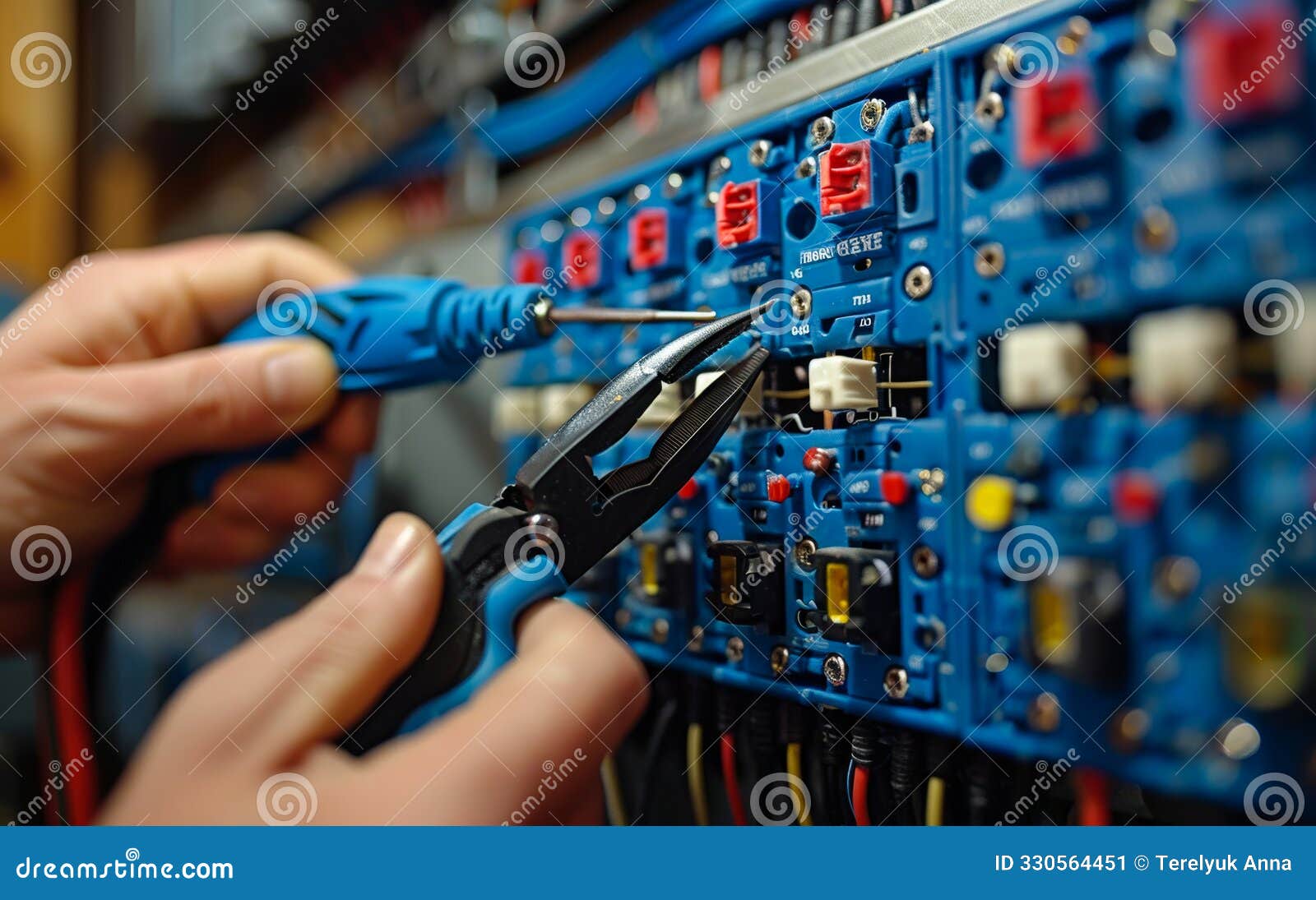An Electrical Technician Uses Tools To Fix Components in a Control ...