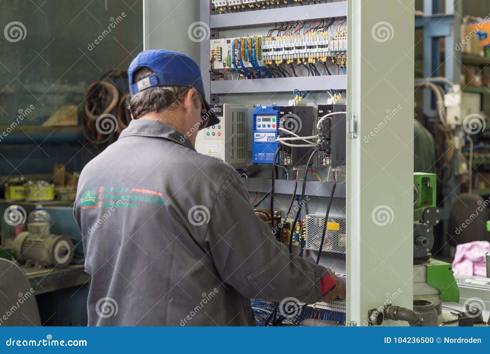 The Electrician Assembles and Adjusts the Electrical Control Cabinet ...