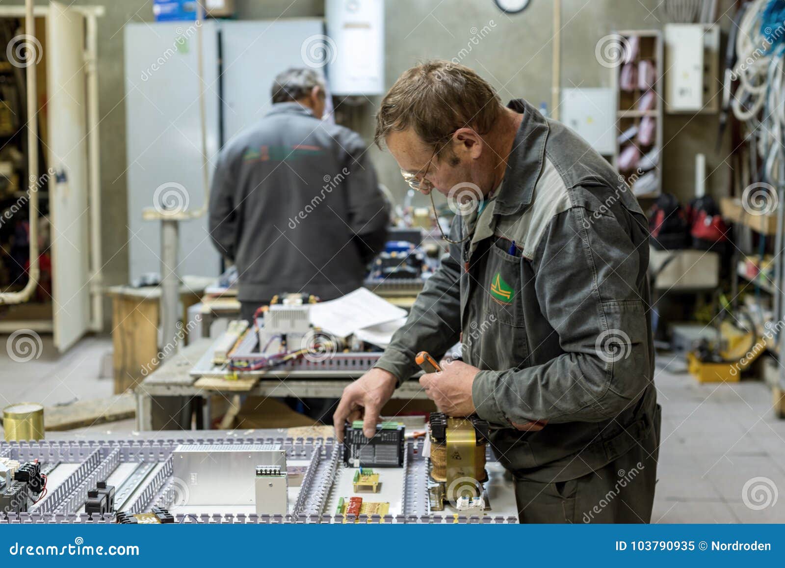 The Electrician Assembles and Adjusts the Electrical Control Panel ...