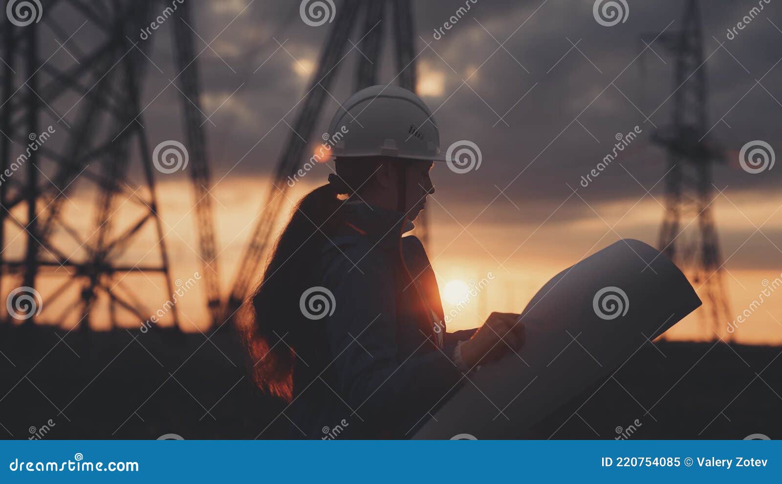 An Electrician on the Background of High Towers of Power Plants Looks ...