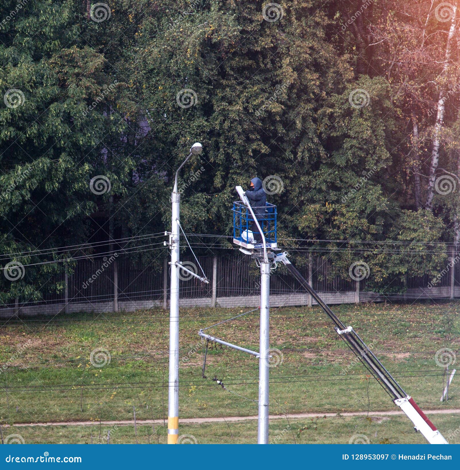 The Electrician Changes the Lamp on the Light Pole, the Car-tower Lifts ...