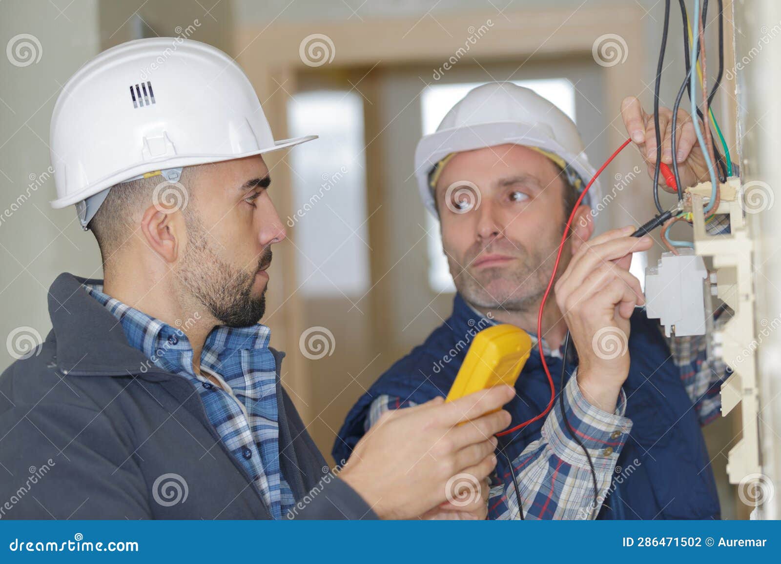 Electrician Checking Socket Voltage with Digital Multimeter Two Workers ...