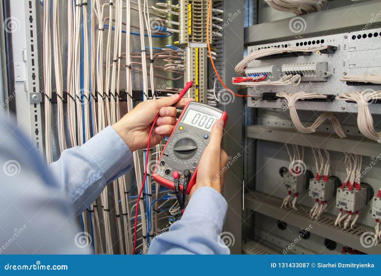Electrician Engineer with Multimeter in Electrical Cabinet. Stock Image ...