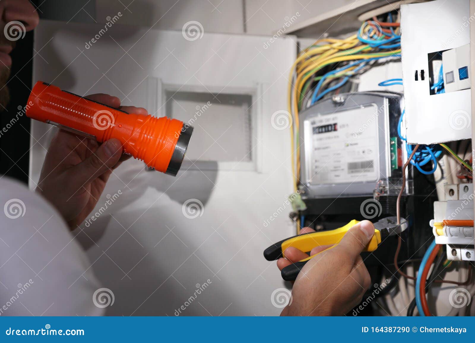 Electrician with Flashlight Fixing Electric Panel Indoors Stock Photo ...