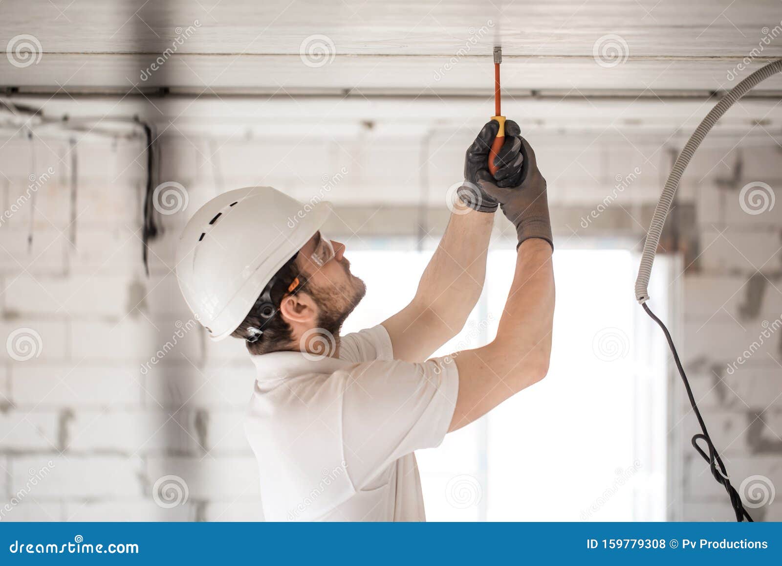 Electrician Installer with a Tool in His Hands, Working with Cable on ...