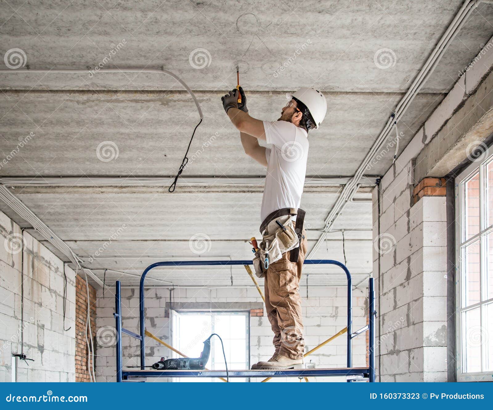 Electrician Installer With A Tool In His Hands, Working With Cable On ...