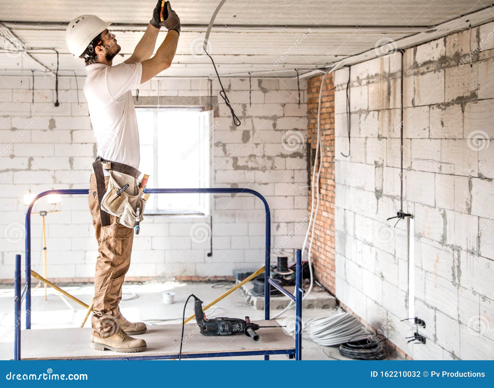 Electrician Installer with a Tool in His Hands, Working with Cable on ...