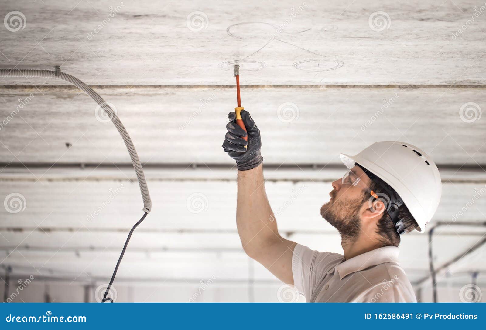 Electrician Installer with a Tool in His Hands, Working with Cable on ...