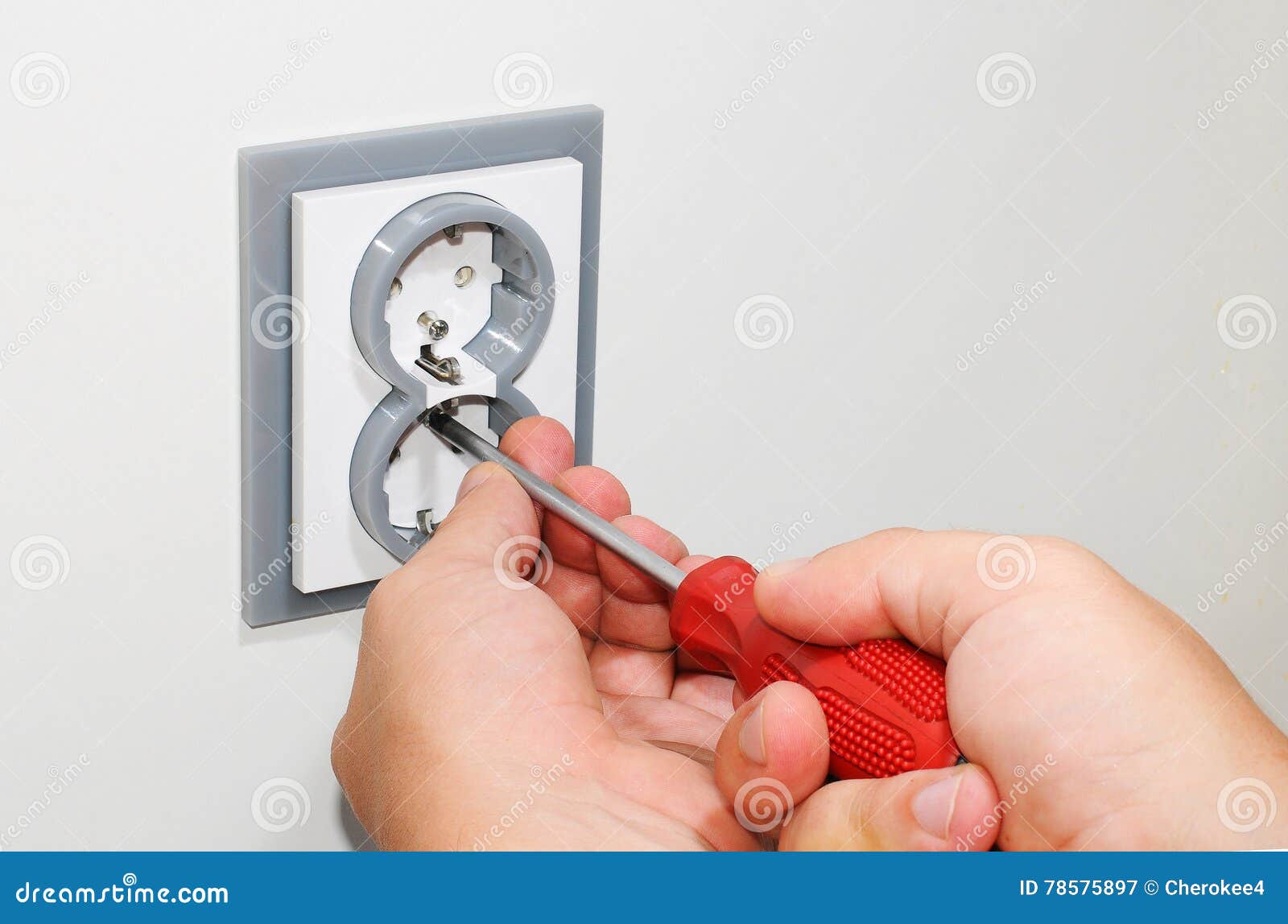 Electrician Installing a Grey Wall-mounted AC Power Socket with a ...