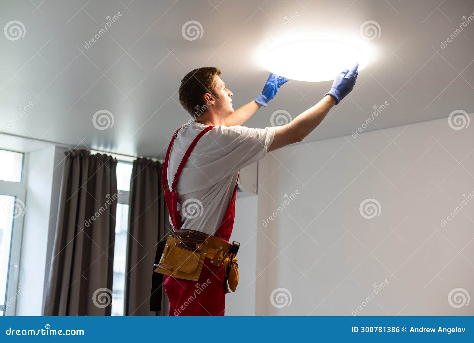An Electrician is Installing LED Spotlights on the Ceiling. Stock Photo ...