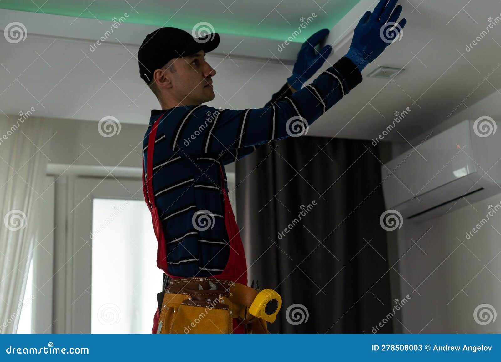 An Electrician is Installing LED Spotlights on the Ceiling. Stock Image ...