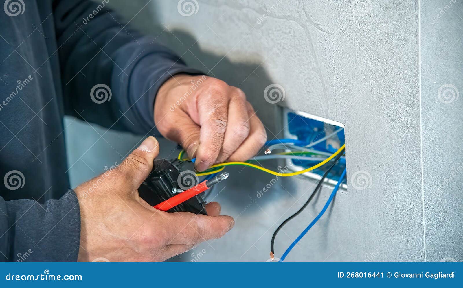 Electrician Mounts an Electrical Outlet To the Wall, Connecting Cables ...