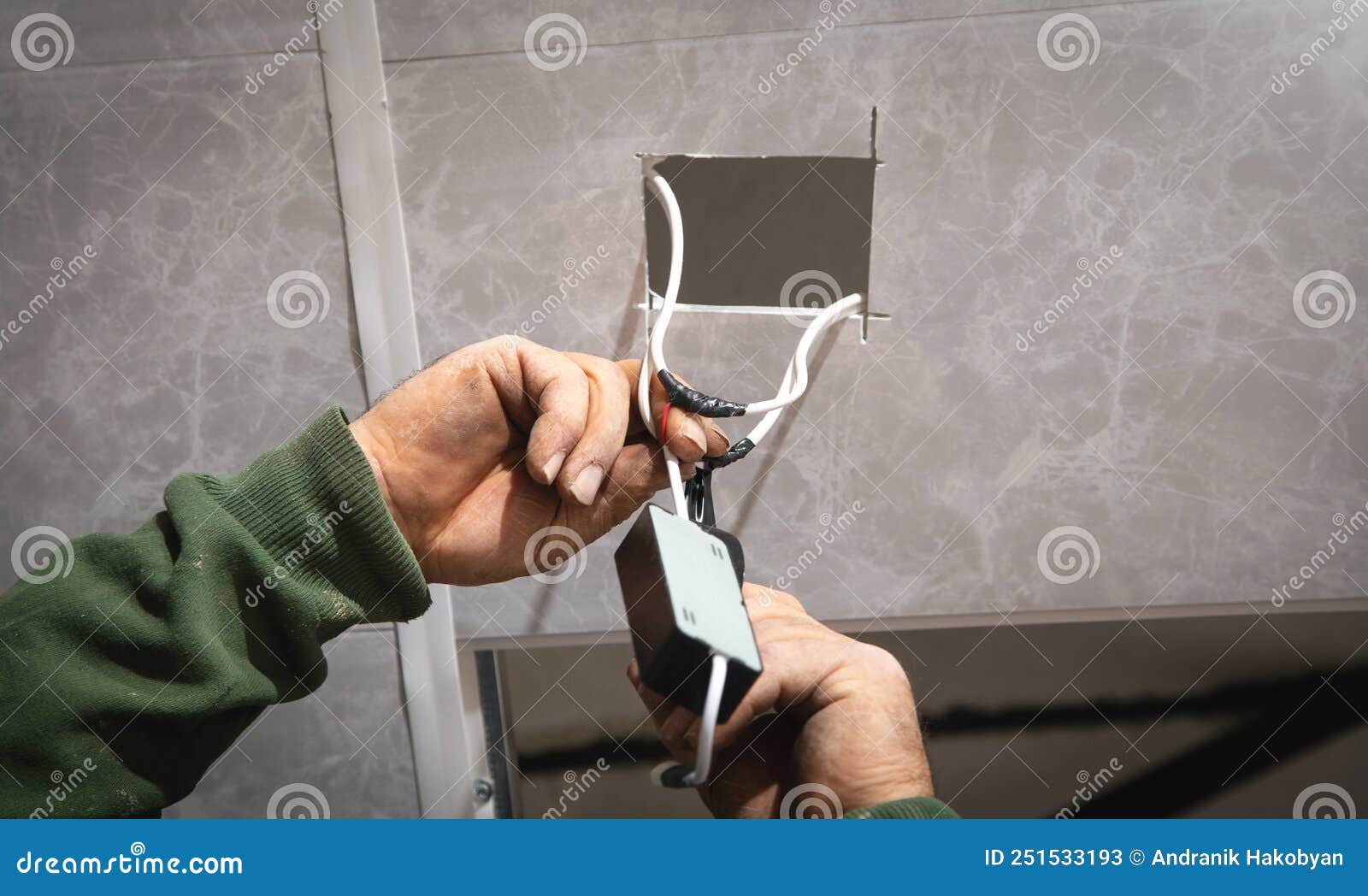 Electrician Performs Electric Installation on the Ceiling of a House ...