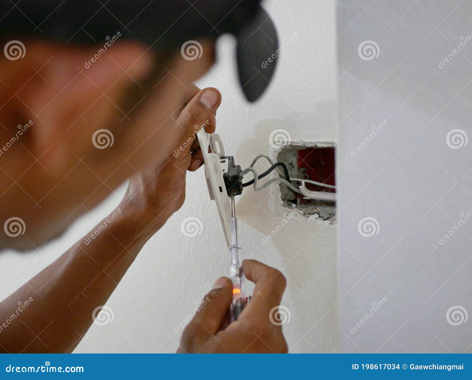 An Electrician`s Hand Holding on a Neon-lamp Type Tester, Screwdriver ...