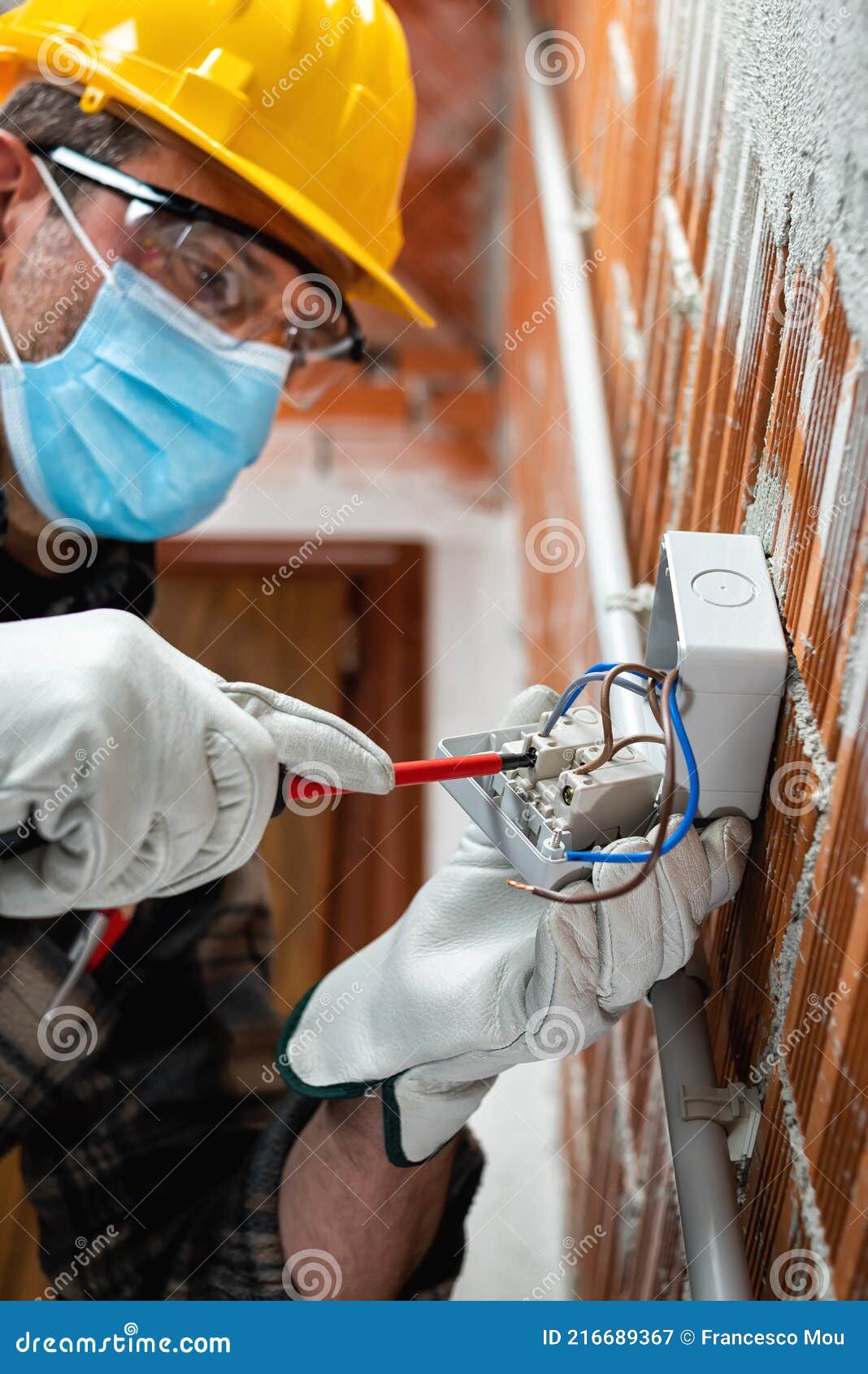 Electrician at Work with Face Protected by Surgical Mask To Prevent ...