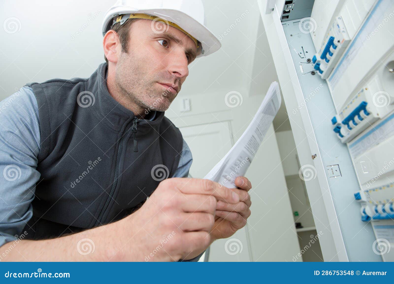 Electrician Studying Electrical Panel Holding Manual Stock Photo ...