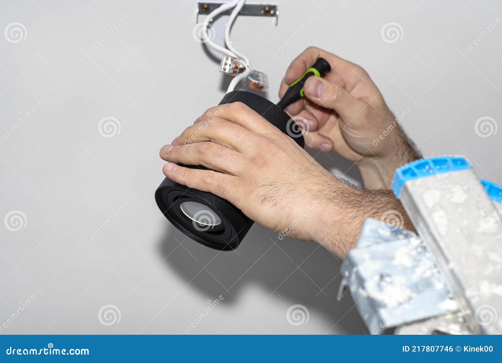 An Electrician, Using a Screwdriver, Assembles Modern LED Lighting in ...