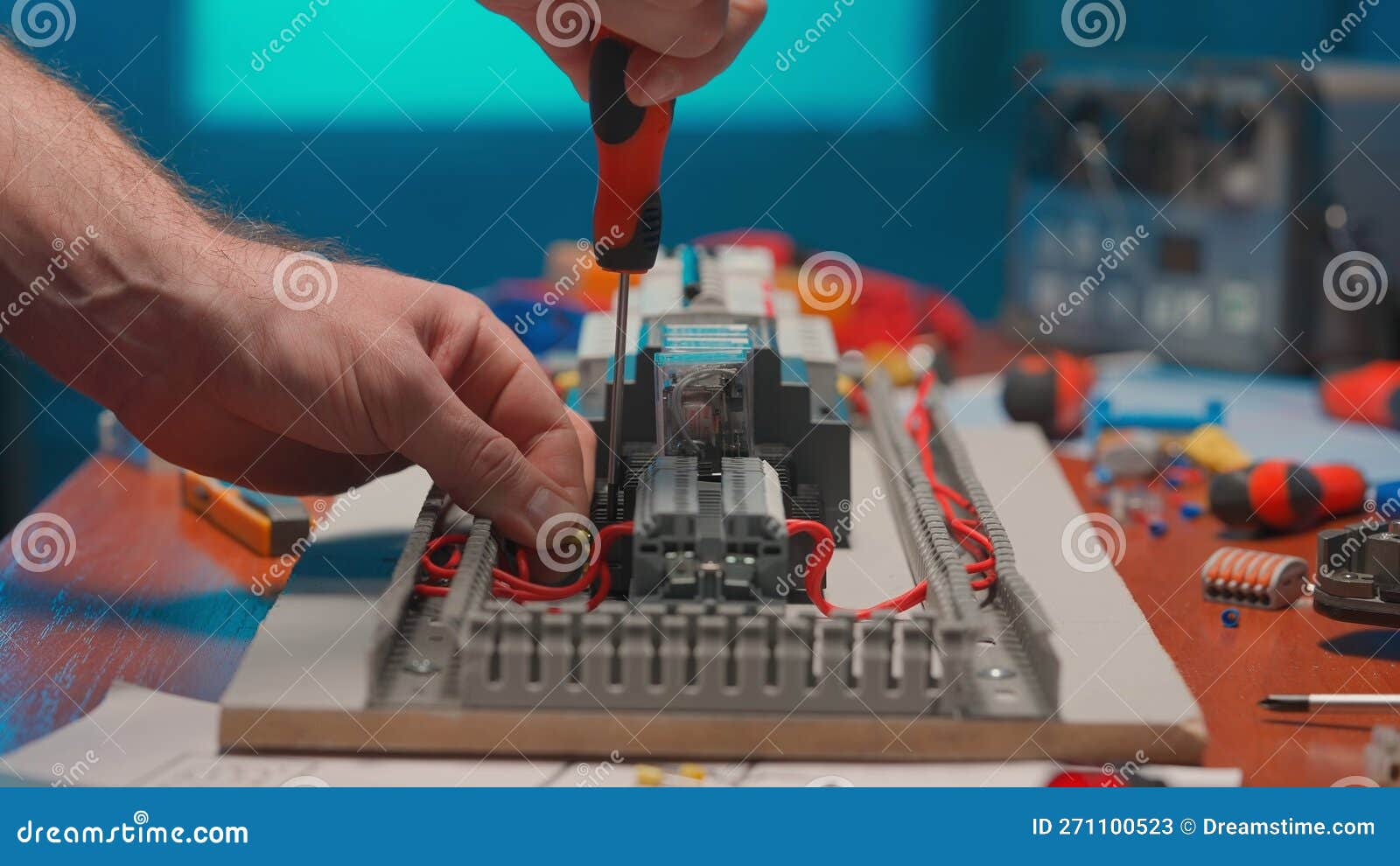 Electrician Using a Screwdriver is Screwing a Red Wire in an Automatic ...