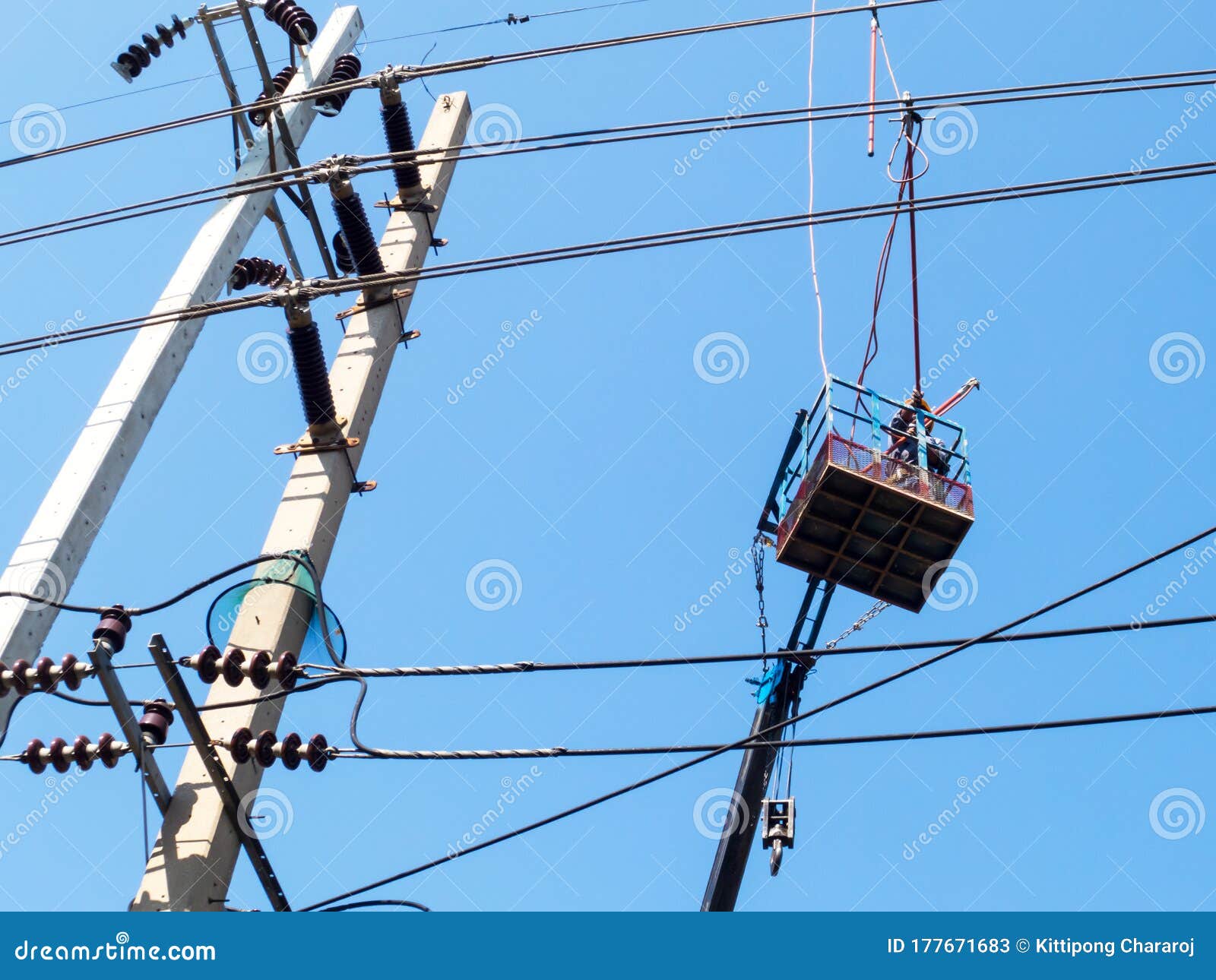 The Electrician is Working on the Crane and the Power Lines on the Blue ...