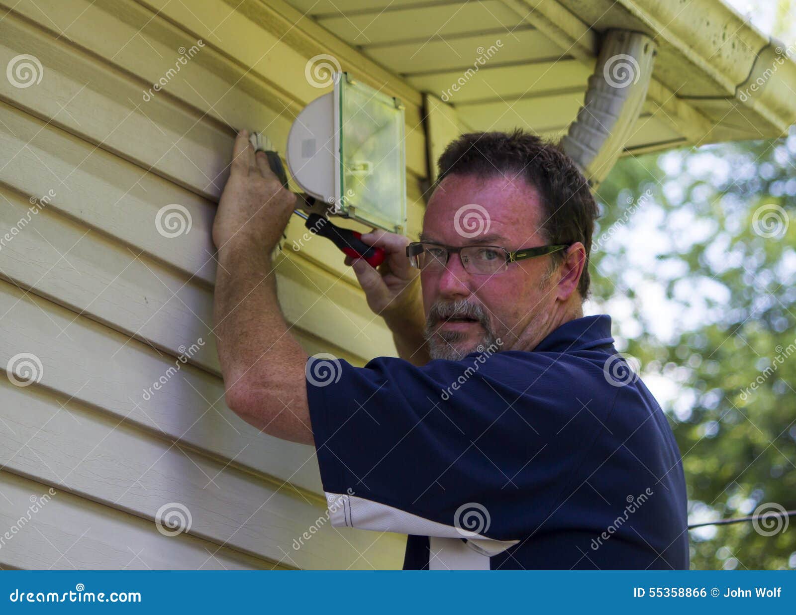 Electrician Working on a Outside Light Stock Photo - Image of light ...