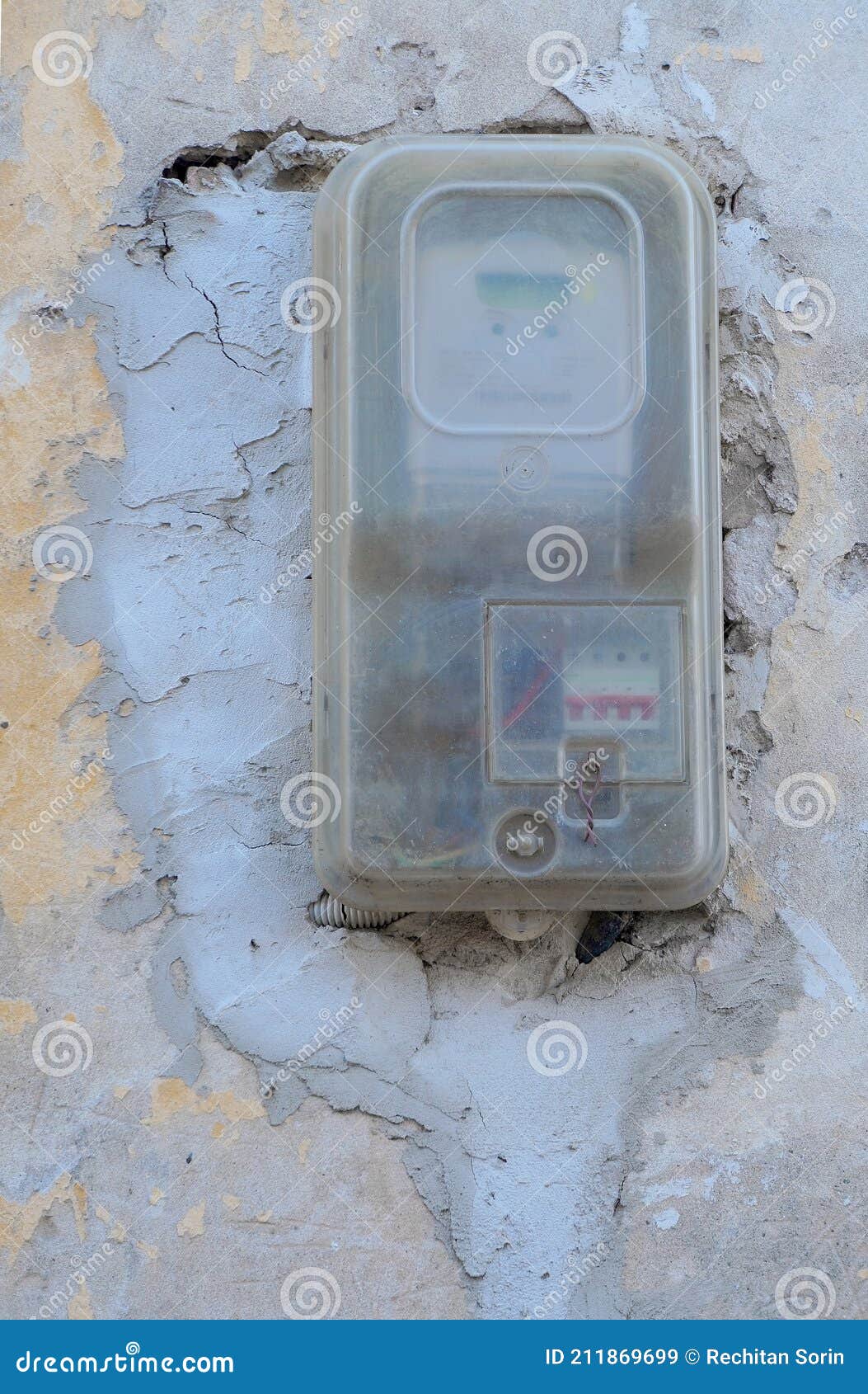 An Electromechanical Electricity Meter on an Old Wall. Meter Measuring ...