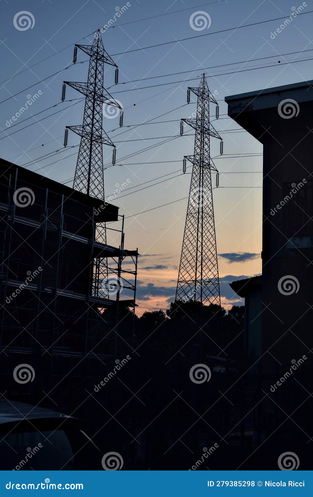Electricity Pylons at Sunset Framed by Buildings Stock Photo - Image of ...